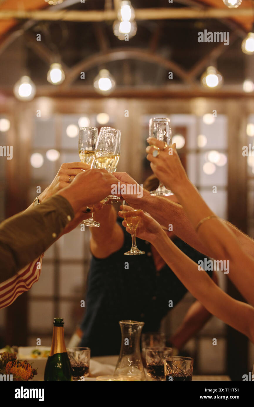 Hands of young people toasting drinks at a party. Young friends having ...