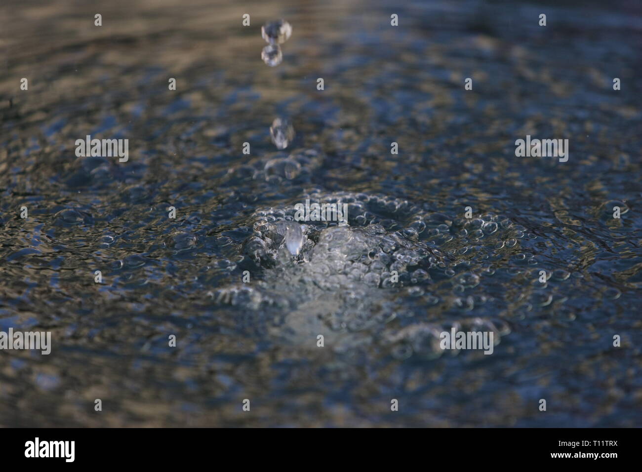 closeup of waterdrops falling into the sparkling water Stock Photo - Alamy
