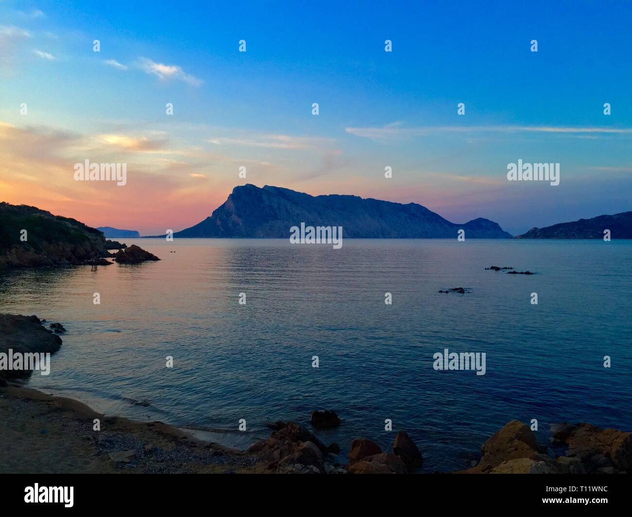 a beautiful view on the beach in sardinia with views of more mountains ...