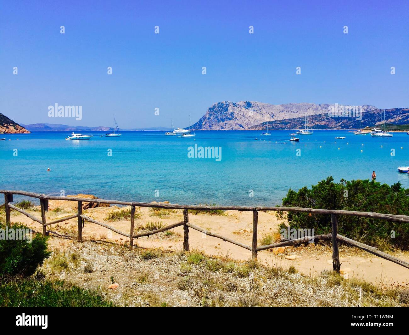 a beautiful view on the beach in sardinia with views of more mountains ...