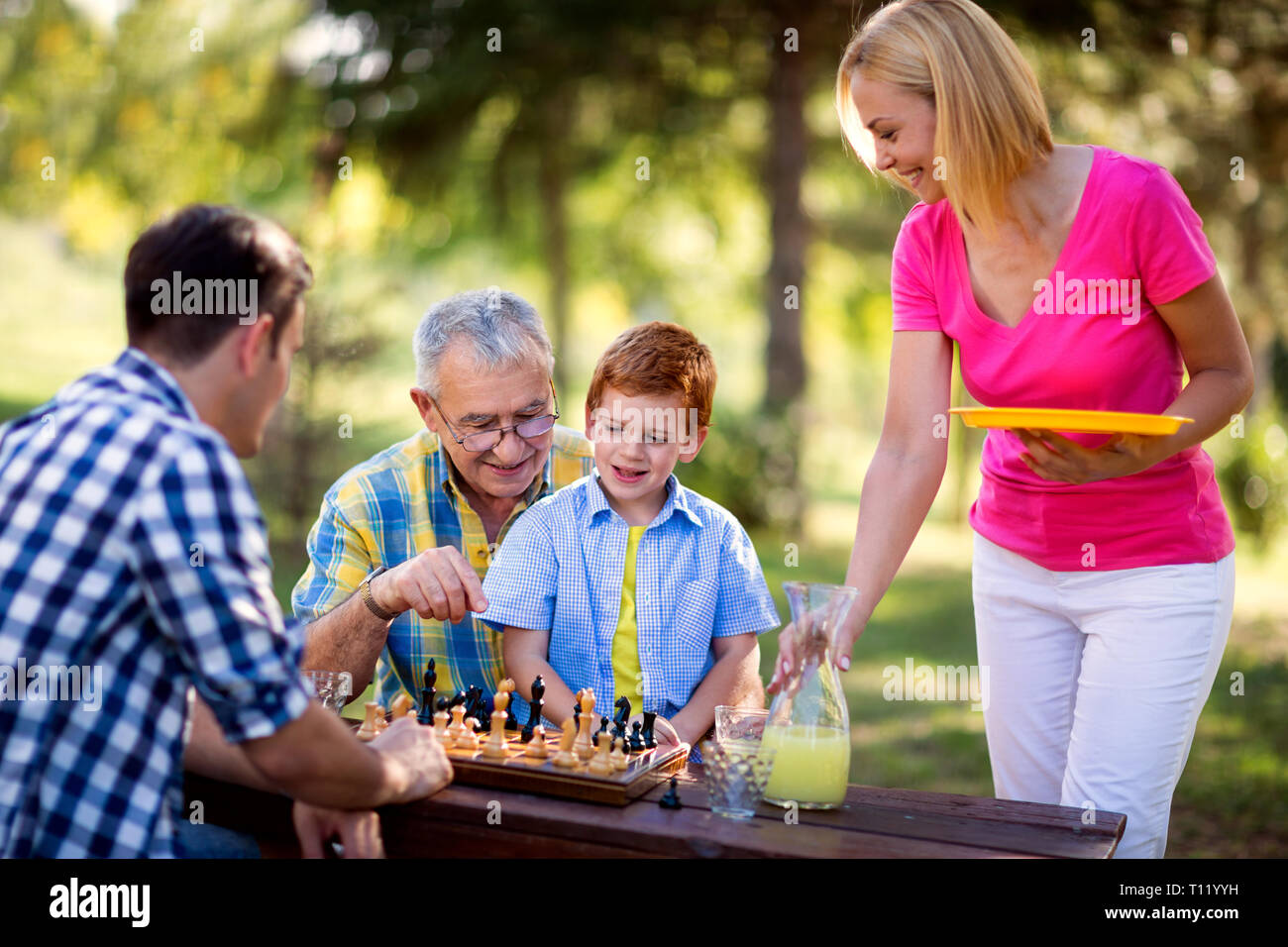 happy family relaxing playing chess in the park Stock Photo - Alamy