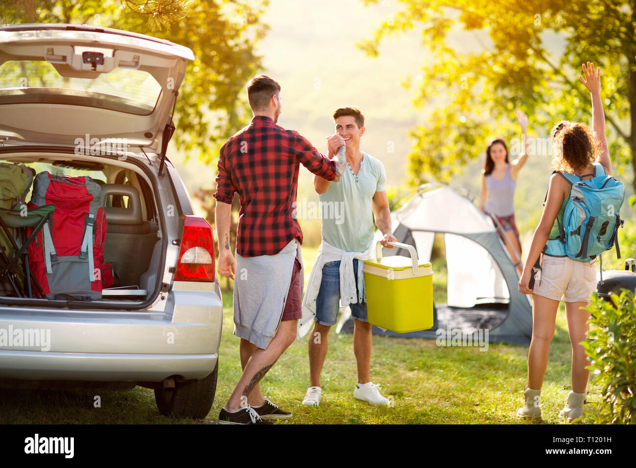 Young people say hello to just arrived friends on a camping trip Stock ...