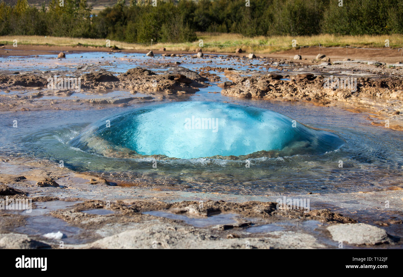 The turquoise blue boiling bubble of Strokkur Geyser In Iceland before ...