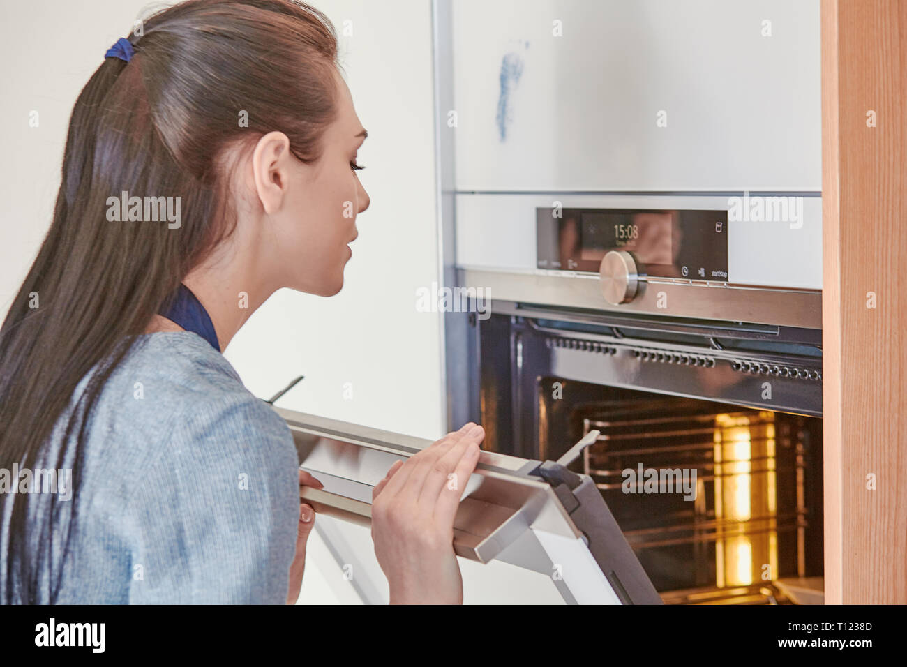 Beautiful woman in the kitchen, waiting with the front of the o Stock ...
