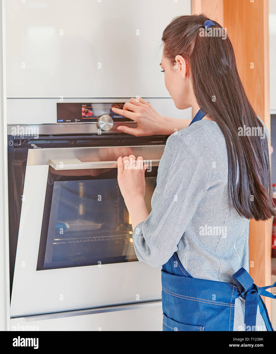 Beautiful woman in the kitchen, waiting with the front of the o Stock ...