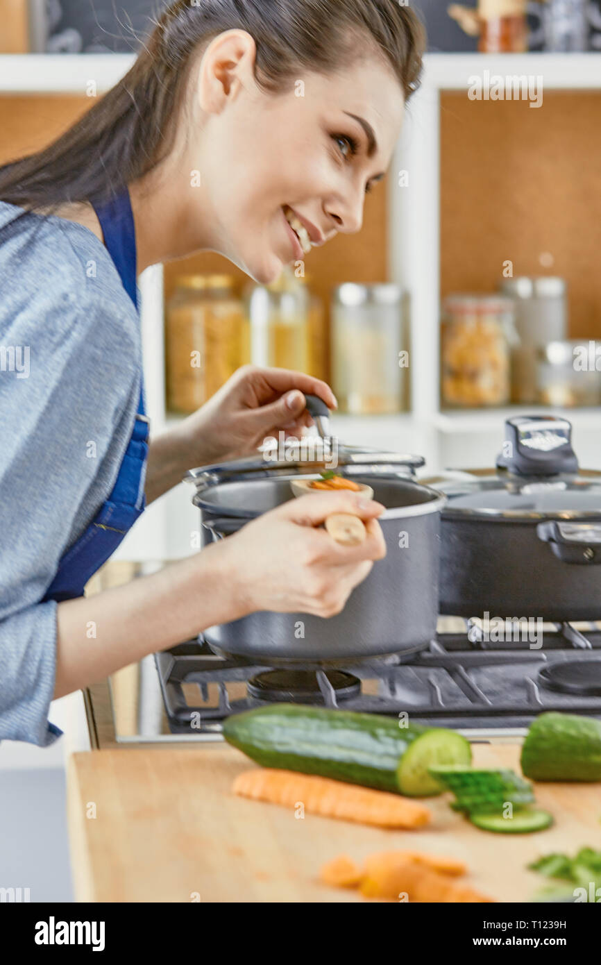 Beautiful girl is tasting food and smiling while cooking in kit Stock ...