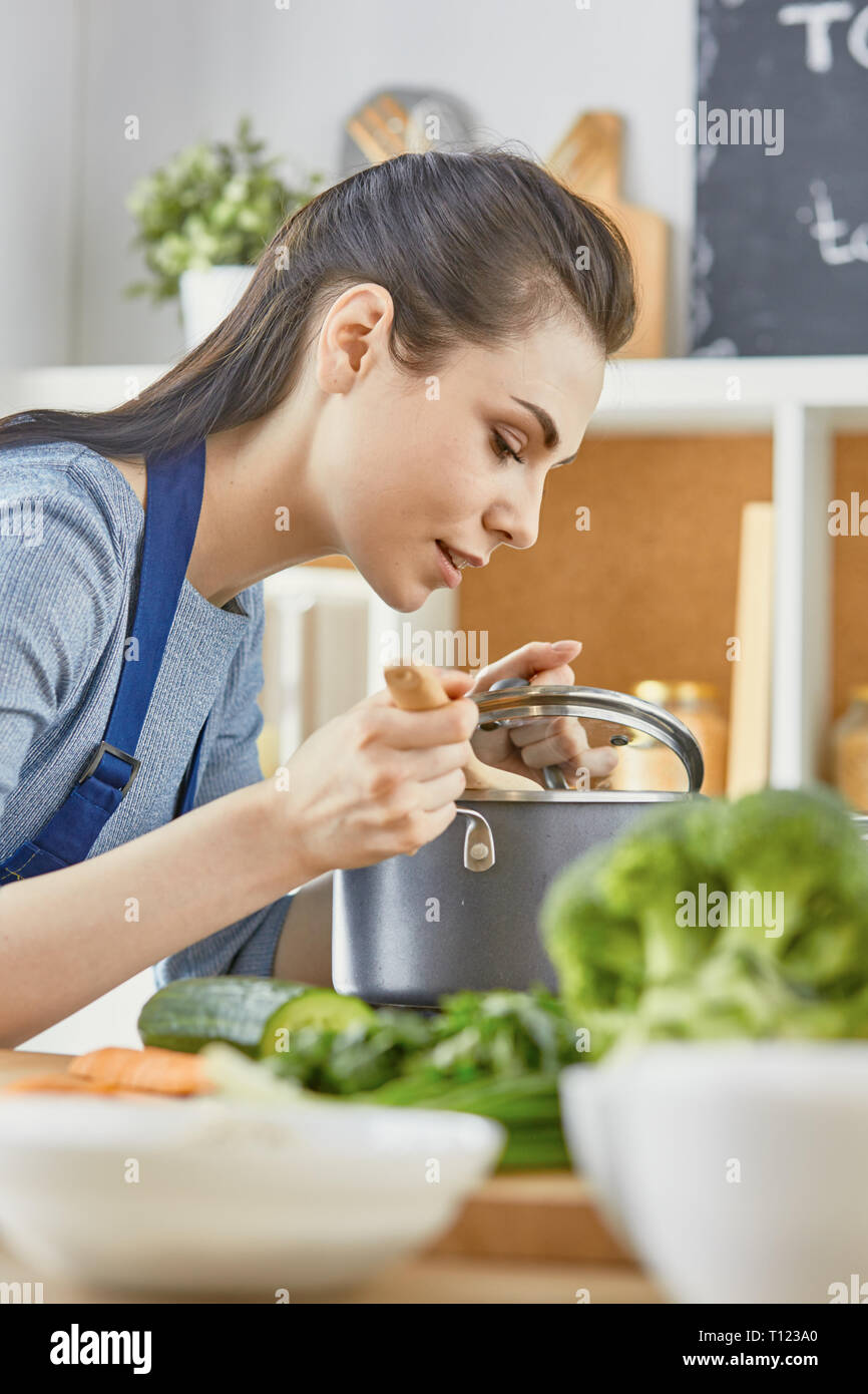 Beautiful girl is tasting food and smiling while cooking in kit Stock ...
