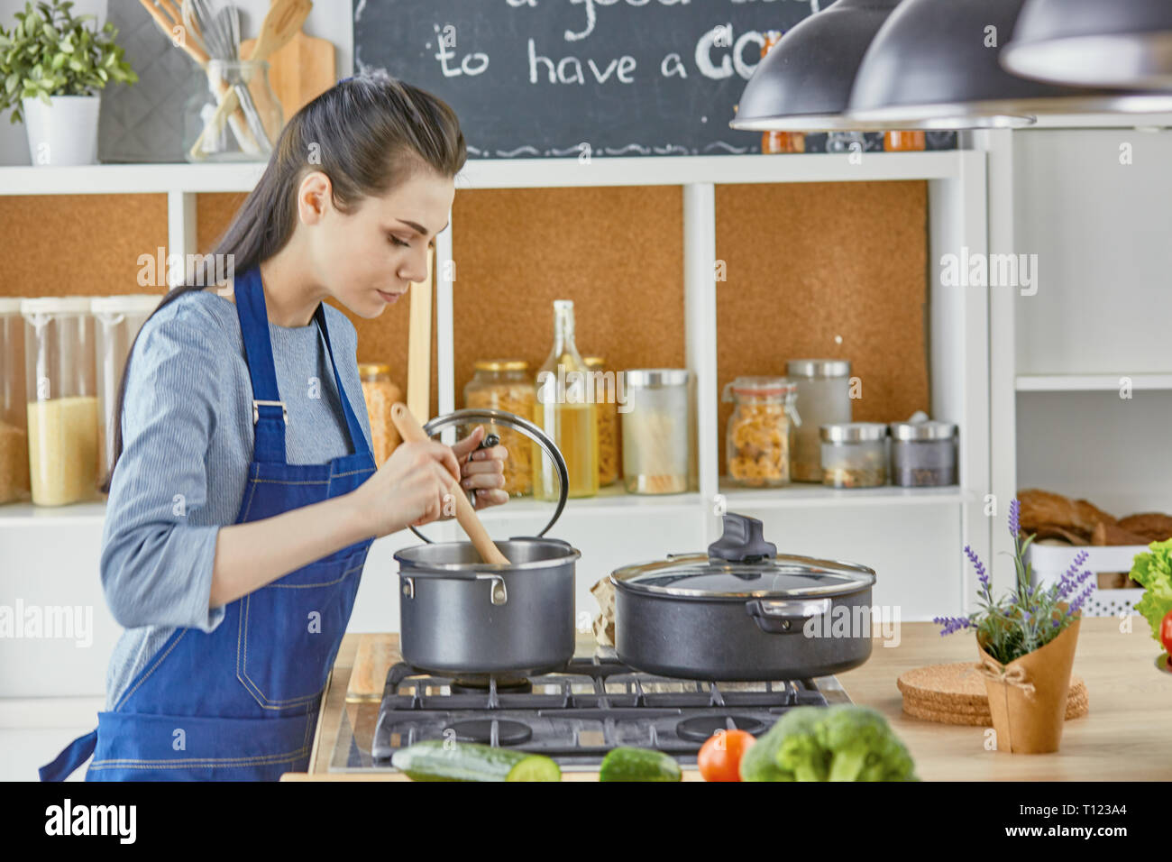 Beautiful girl is tasting food and smiling while cooking in kit Stock ...
