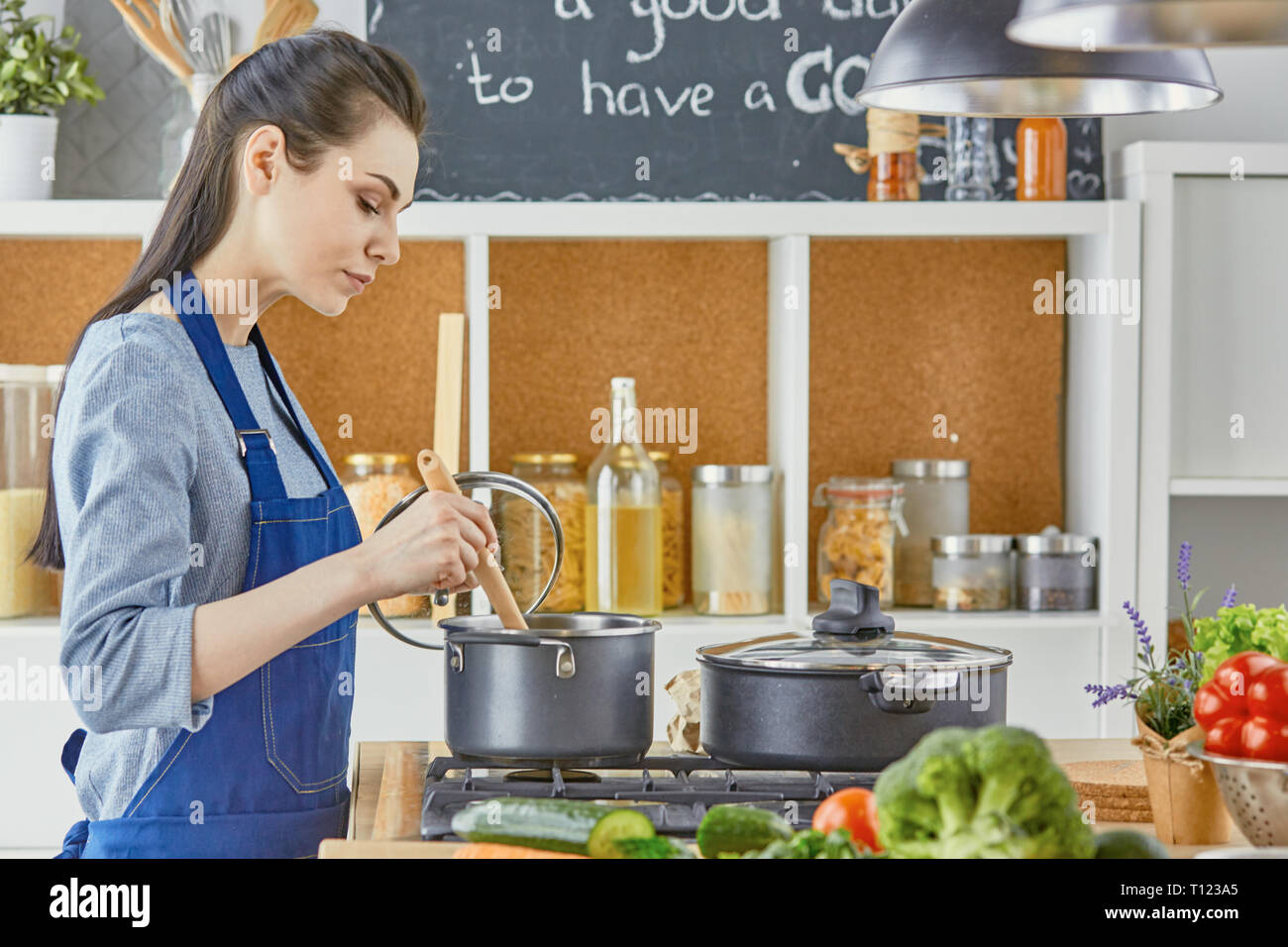 Beautiful girl is tasting food and smiling while cooking in kit Stock ...