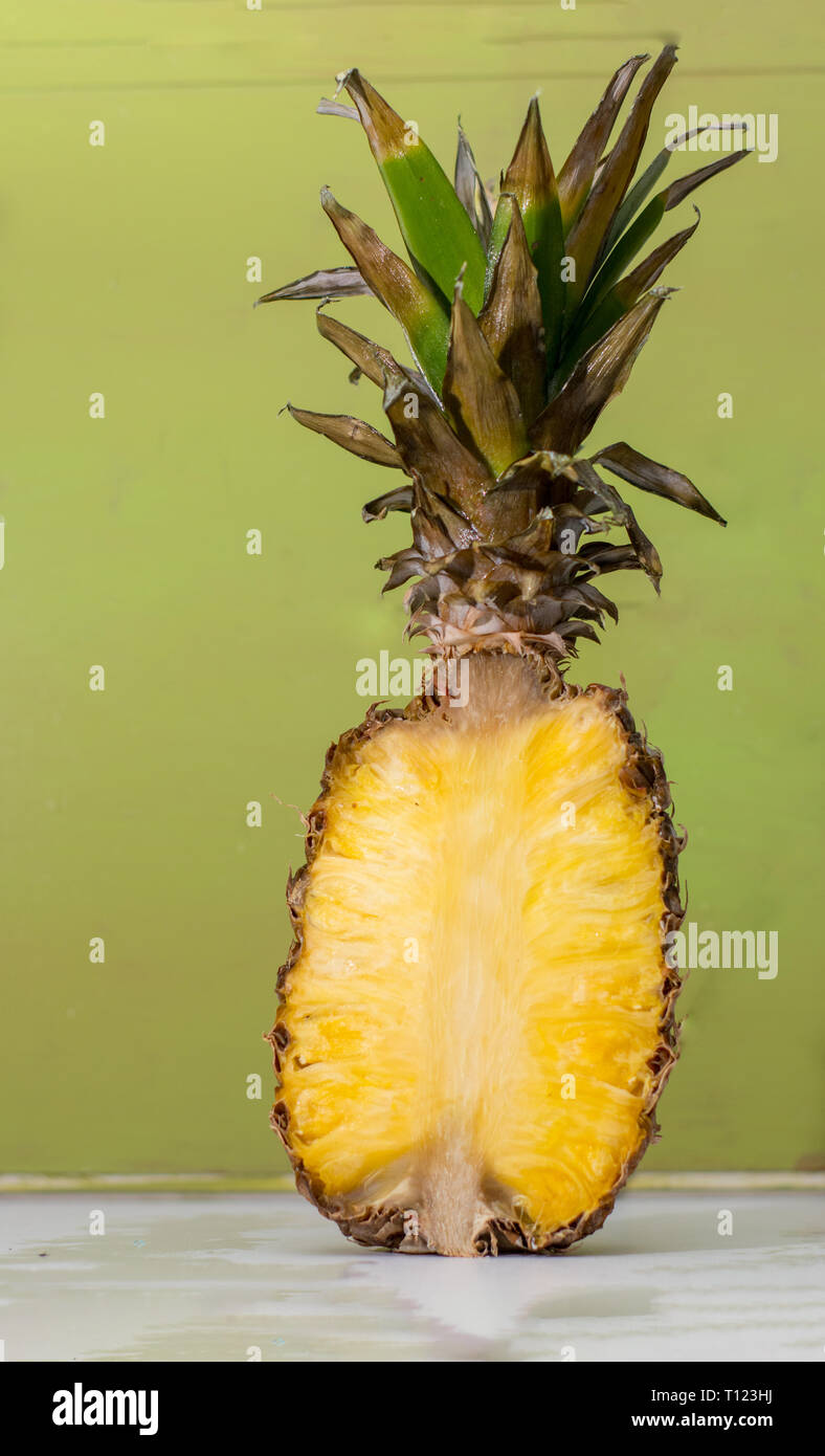 pineapple cut in different shapes with green background and splash of ...