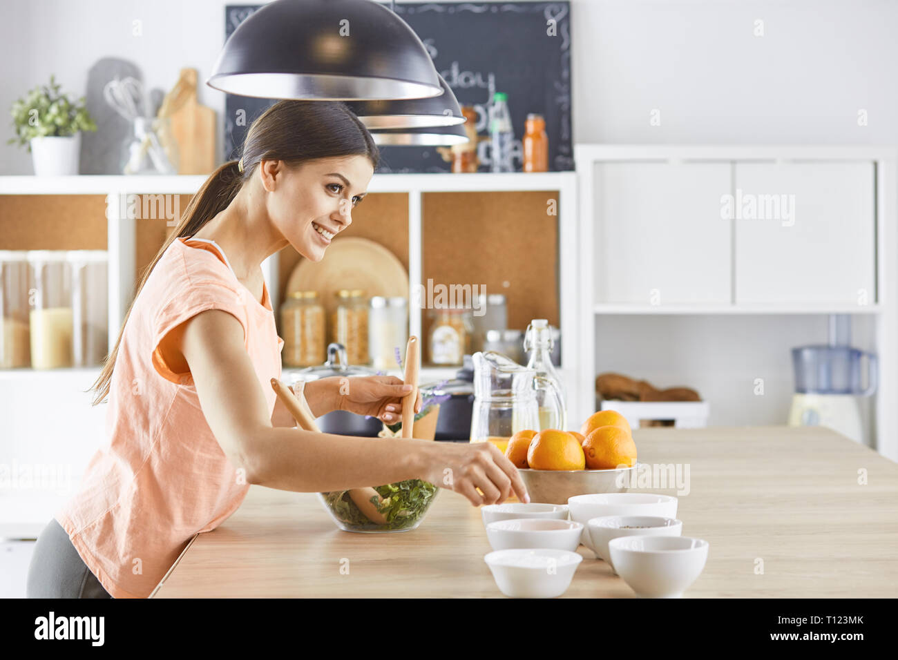 Happy young cook girl preparing food from greens Stock Photo - Alamy