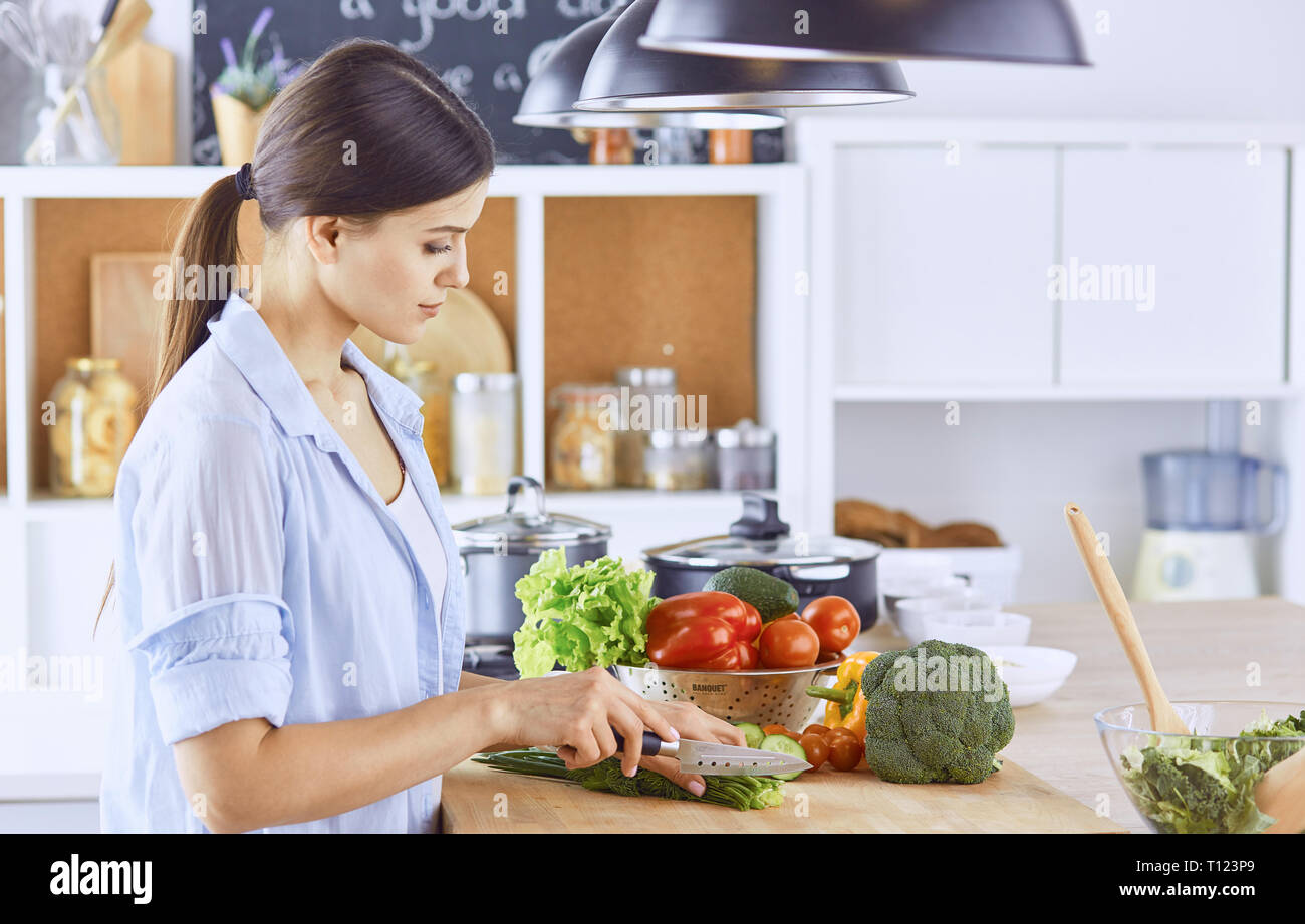 A young woman prepares food in the kitchen. Healthy food - vege Stock ...