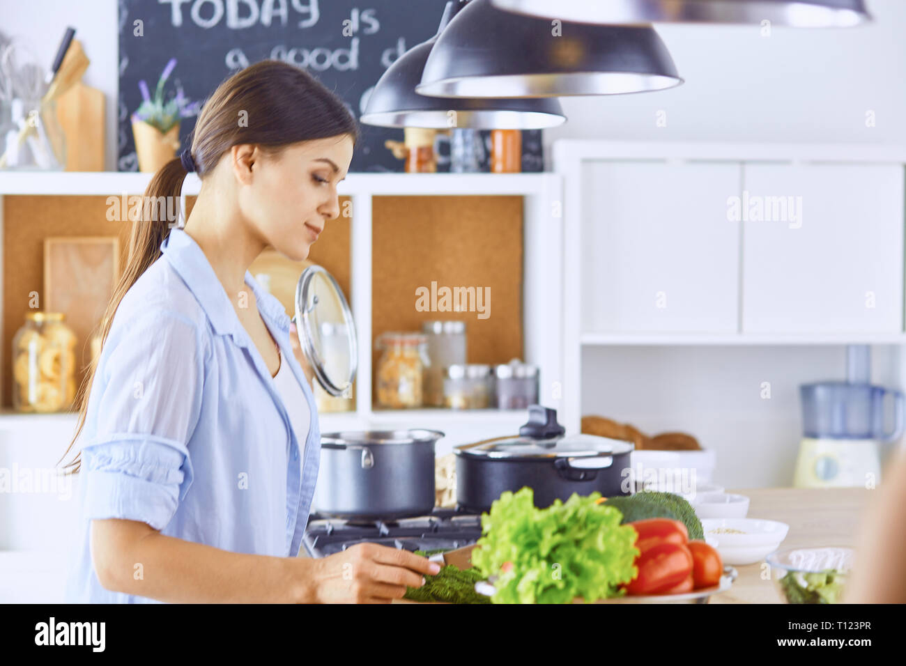 A young woman prepares food in the kitchen. Healthy food - vege Stock ...