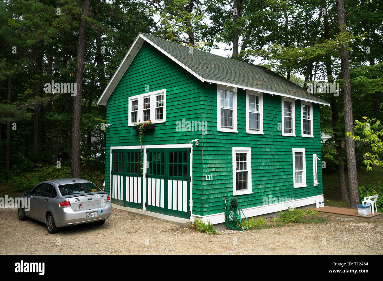 Bright green shingled house with white trimmings and wide double doors ...