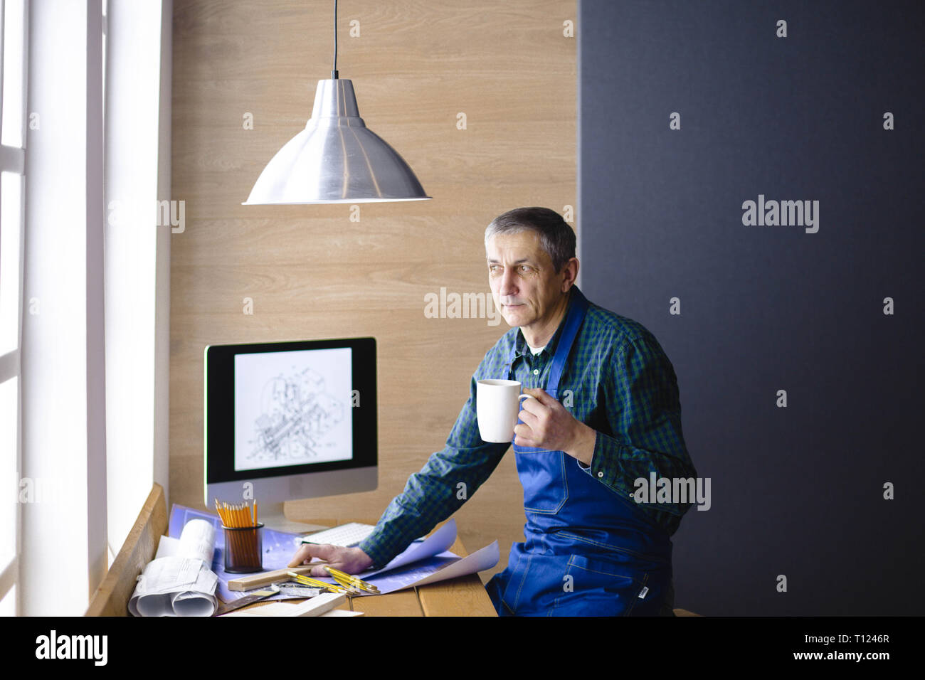 Engineer carpenter working on laptop and sketching project Stock Photo ...