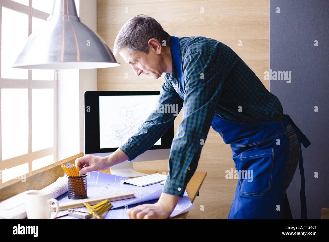 Engineer carpenter working on laptop and sketching project Stock Photo ...
