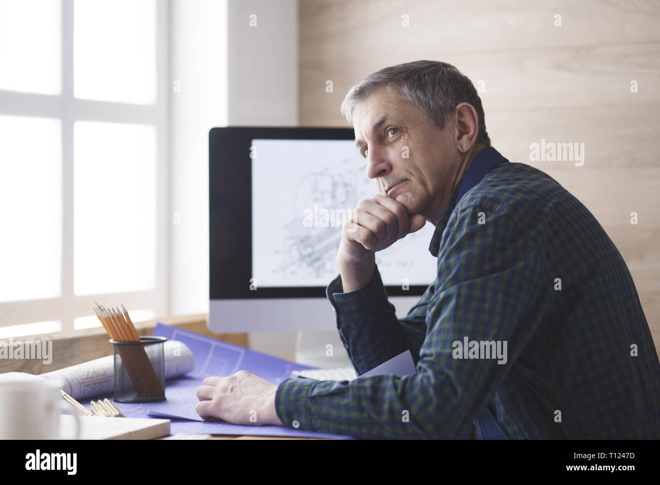 Engineer carpenter working on laptop and sketching project Stock Photo ...