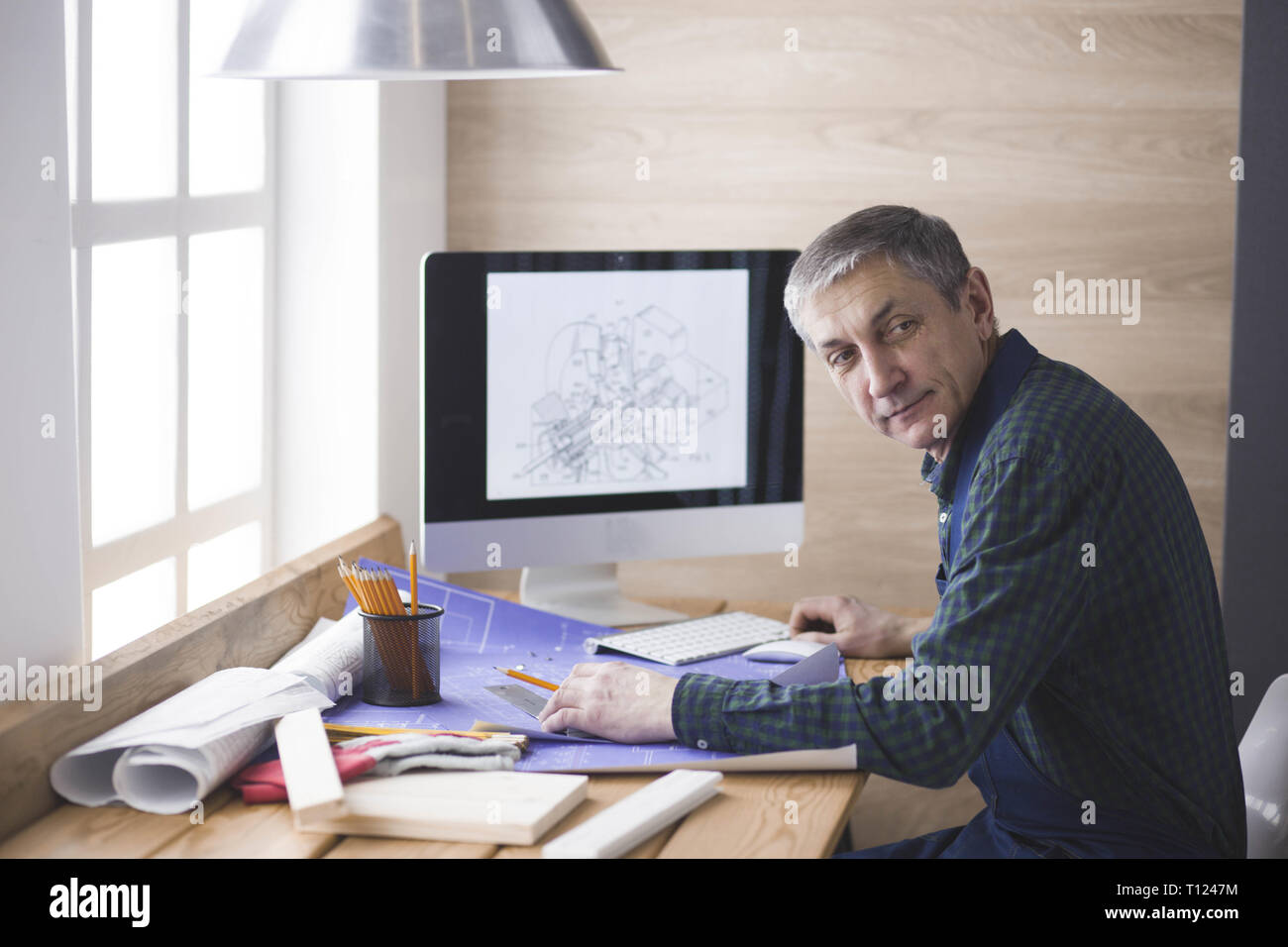 Engineer carpenter working on laptop and sketching project Stock Photo ...