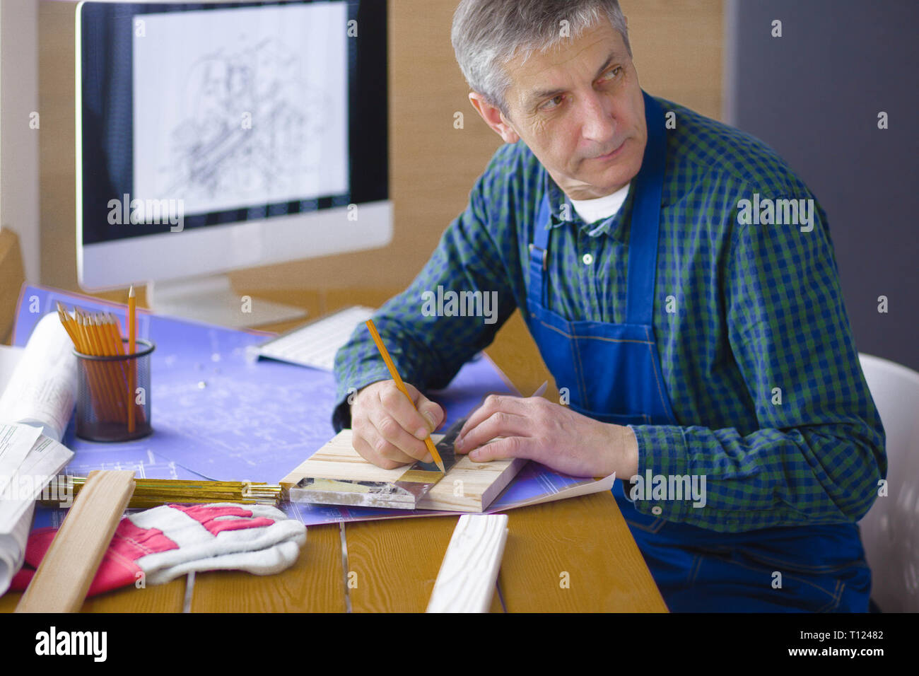 Engineer carpenter working on laptop and sketching project Stock Photo ...