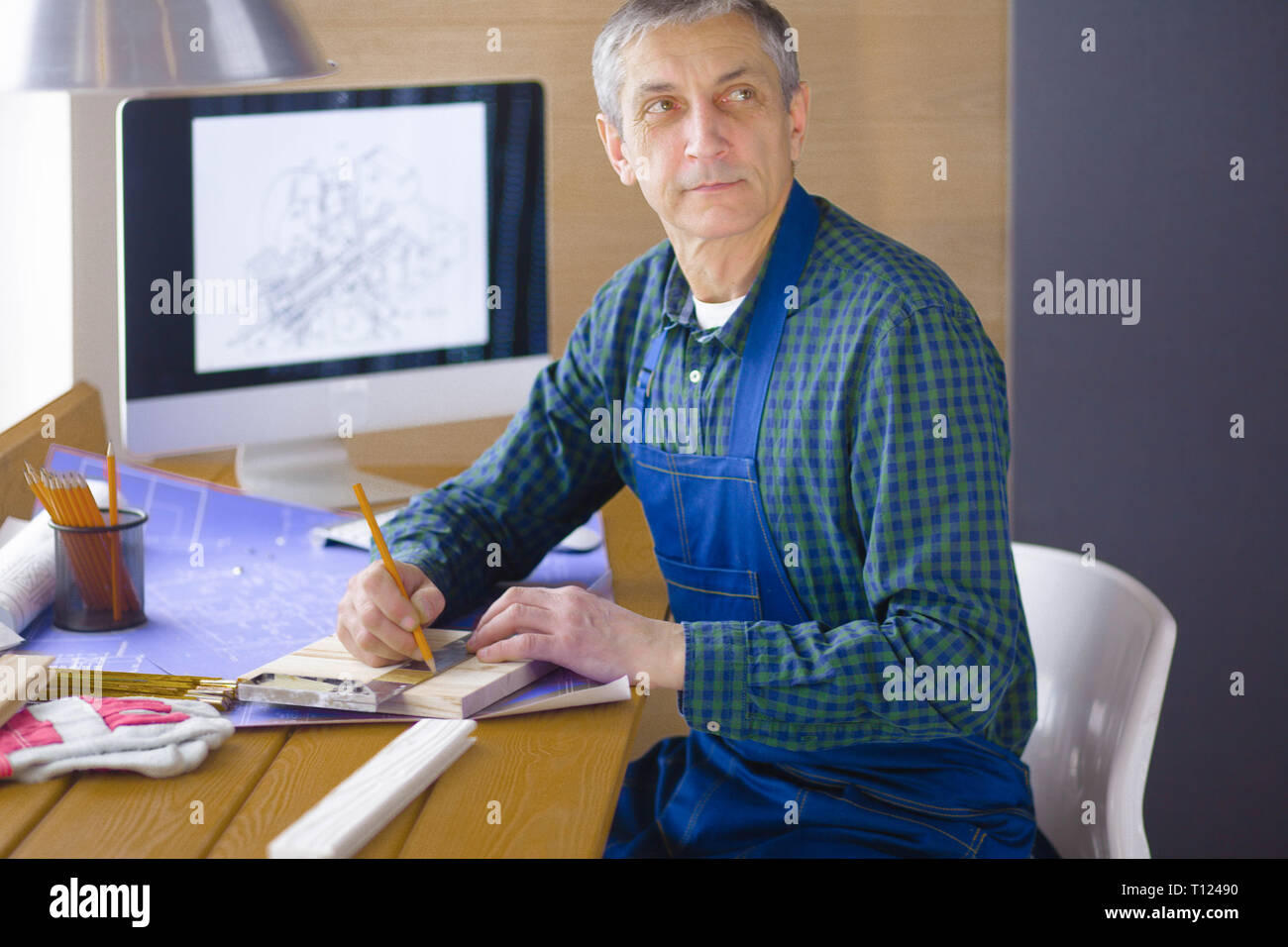 Engineer carpenter working on laptop and sketching project Stock Photo ...