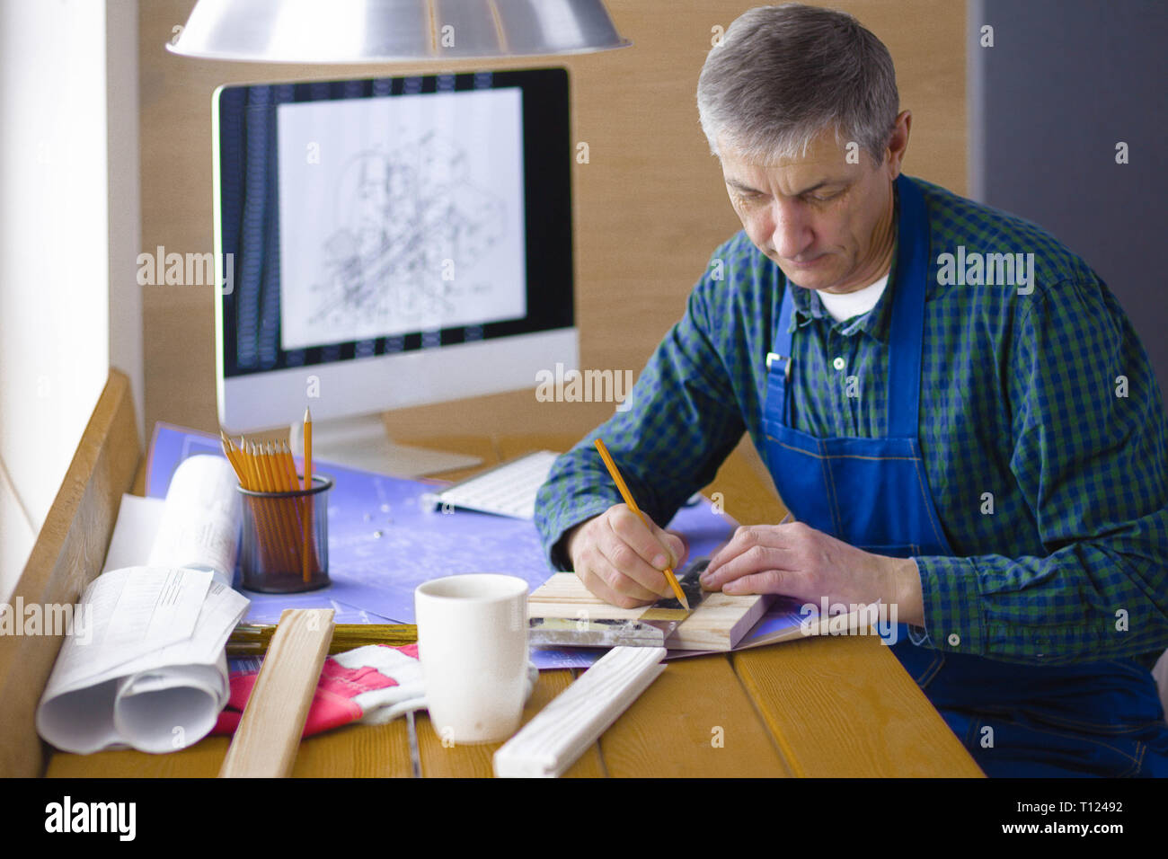 Engineer carpenter working on laptop and sketching project Stock Photo ...