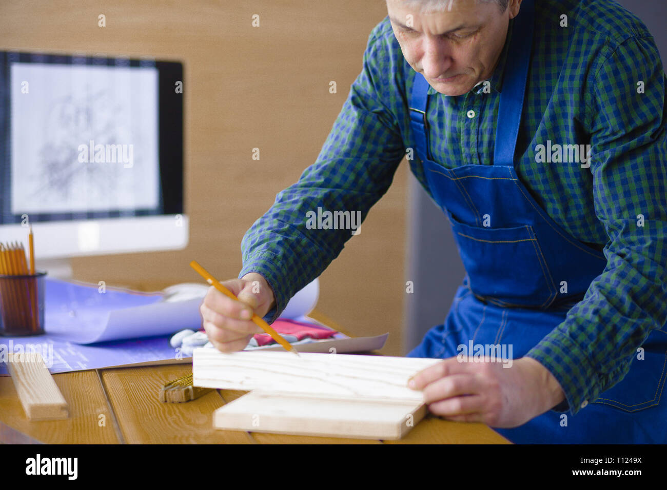 Engineer carpenter working on laptop and sketching project Stock Photo ...