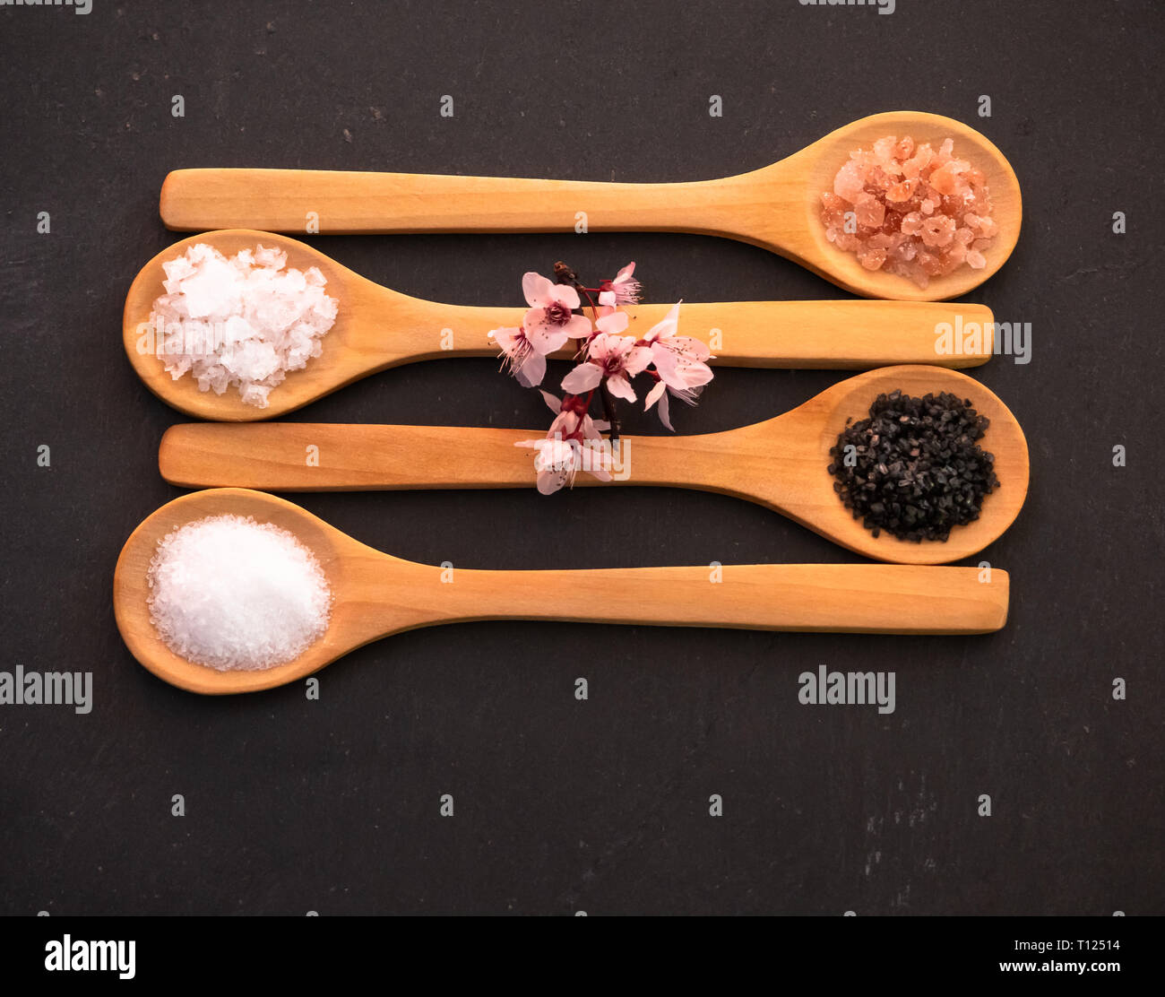 Wooden spoons with himalayan salt, black hawaii salt, common salt and ...