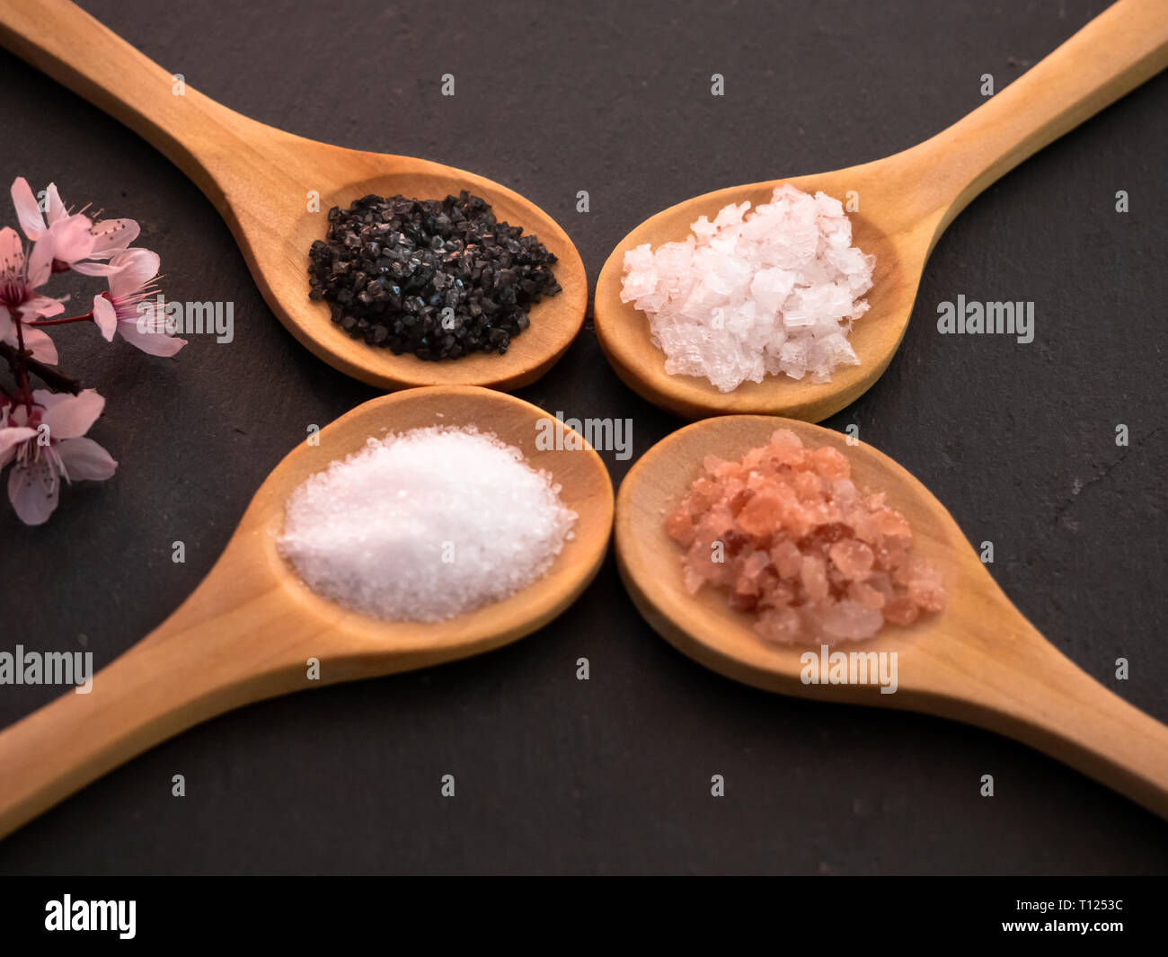 Wooden spoons with himalayan salt, black hawaii salt, common salt and ...