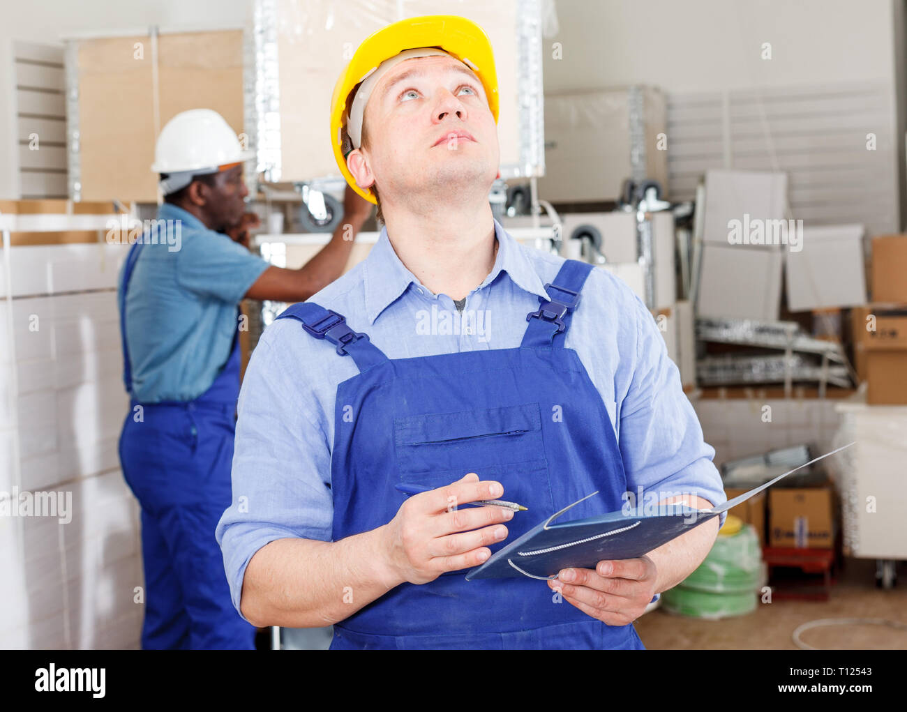 Professional male contractor looking at room and determining scope of ...