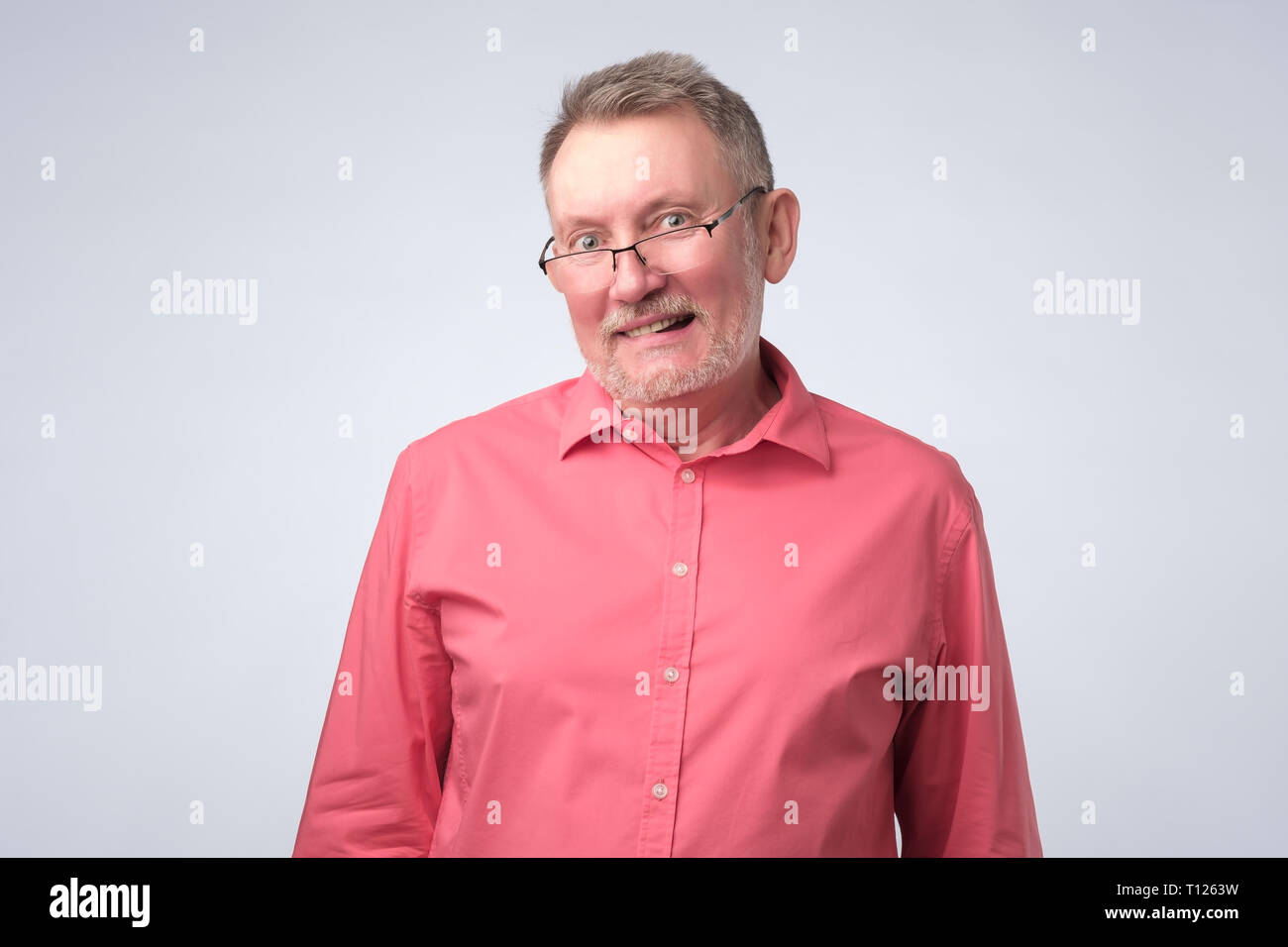 Serious man in red shirt wearing glasses smiling confident. Positive ...