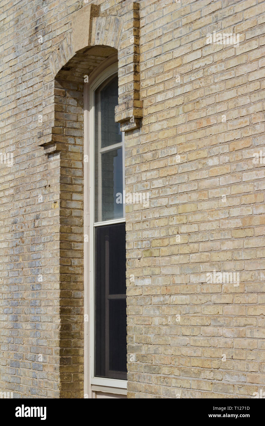 Old beige color brick building facade with tall narrow windows Stock ...