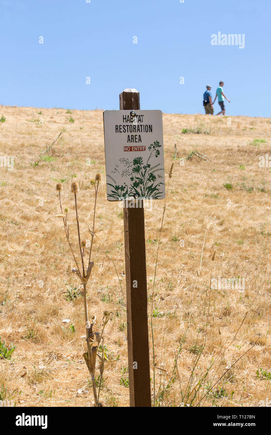 Habitat Restoration Area sign with hikers in the distance at Spring ...