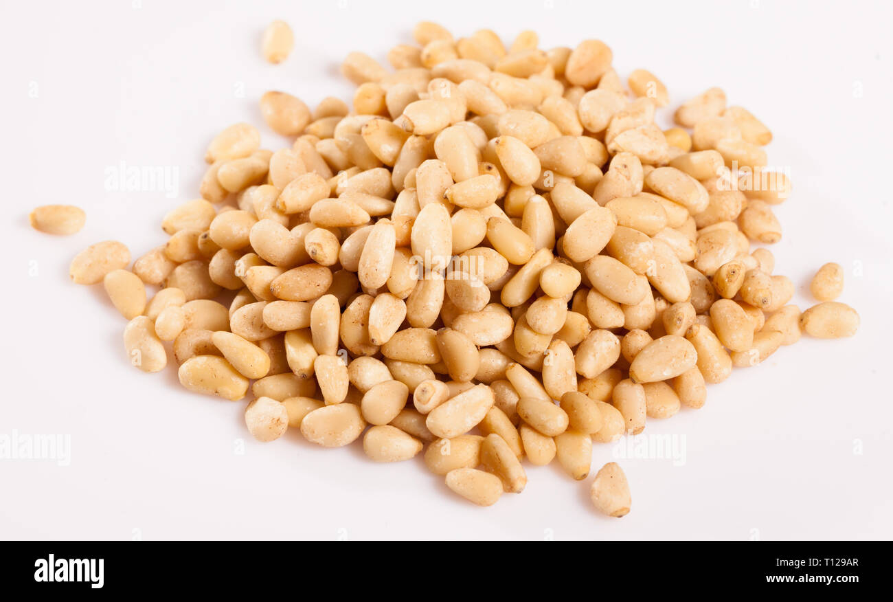 Healthy snack. Heap of shelled pine nuts on white background Stock ...