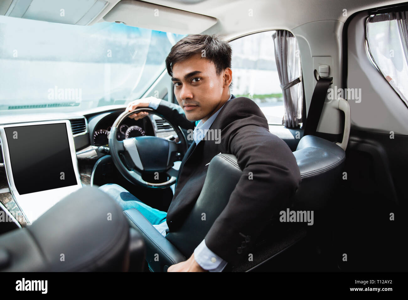 driver in his suit driving luxurious car Stock Photo - Alamy