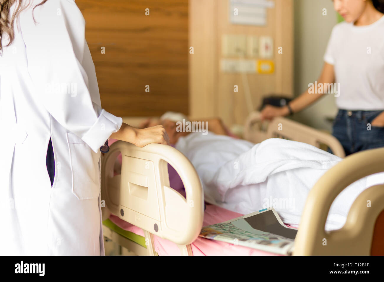 Doctor discussing with patient daughter while patient's in bed at ...