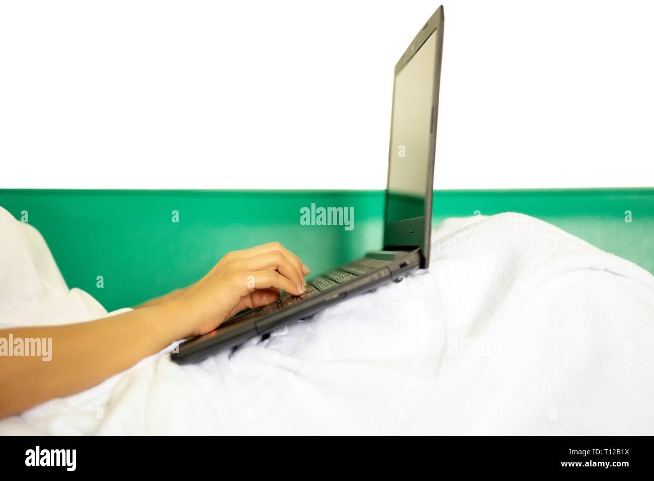 Woman hand typing on keyboard laptop lying in green couch Stock Photo ...