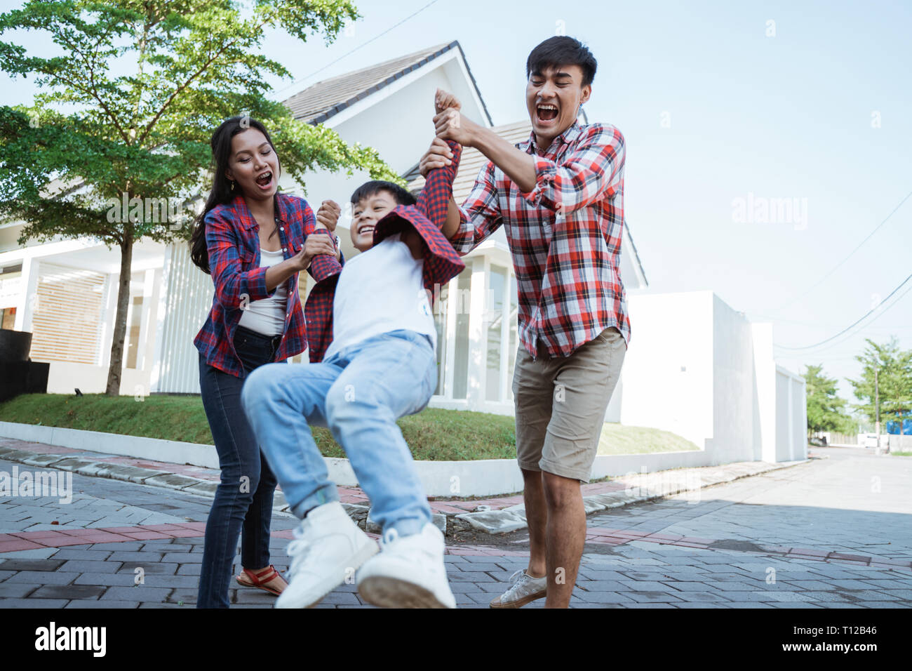family and kid enjoy playing together in front of their house Stock ...