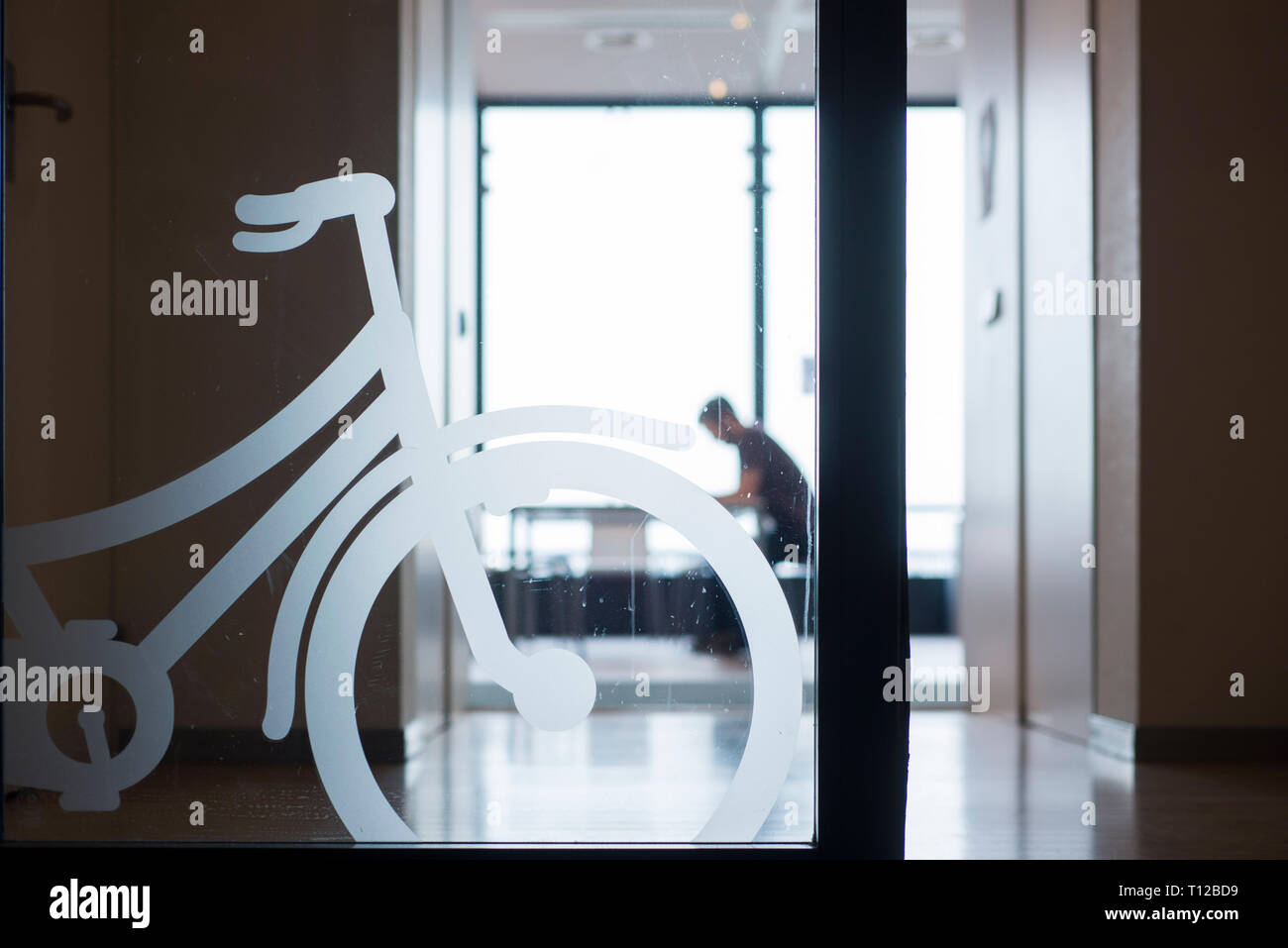 a glass door with a sticker / motive of a bike on the window in a ...