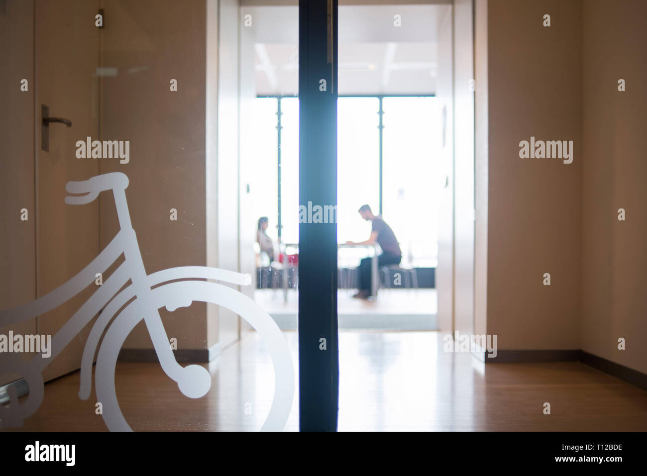 a glass door with a sticker / motive of a bike on the window in a ...