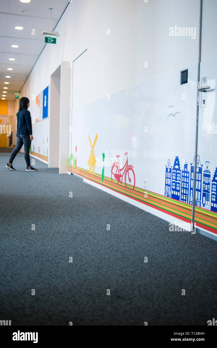 a figure walks along a corridor in a modern building with decoration ...