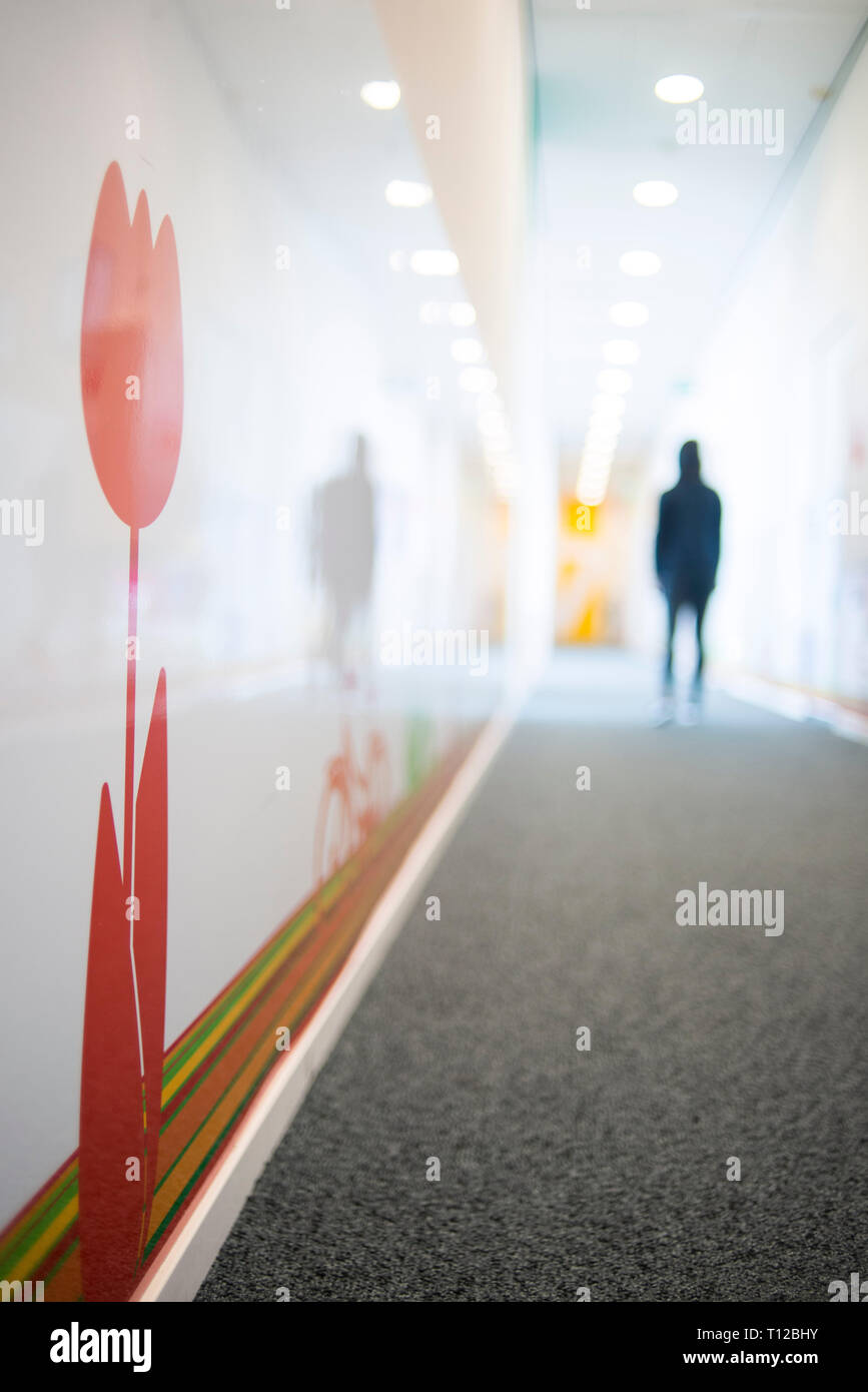 a figure walks along a corridor in a modern building with decoration ...
