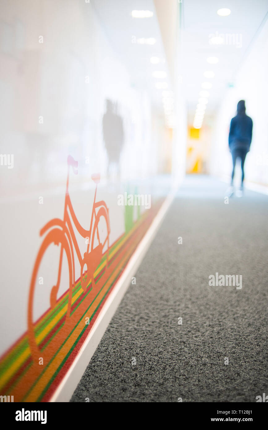 a figure walks along a corridor in a modern building with decoration ...