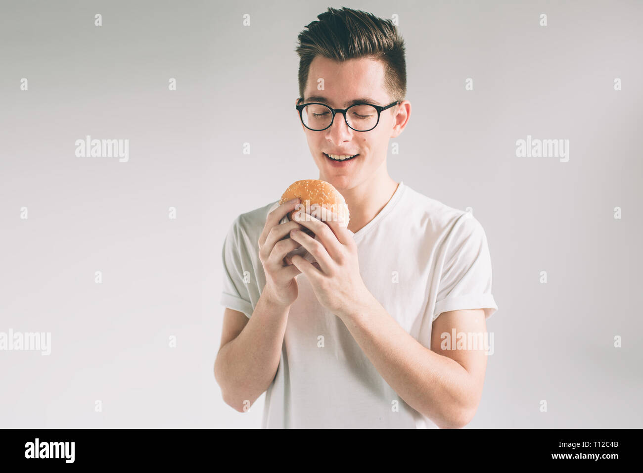 man holding . student eats fast food. not helpful food. very hungry man ...