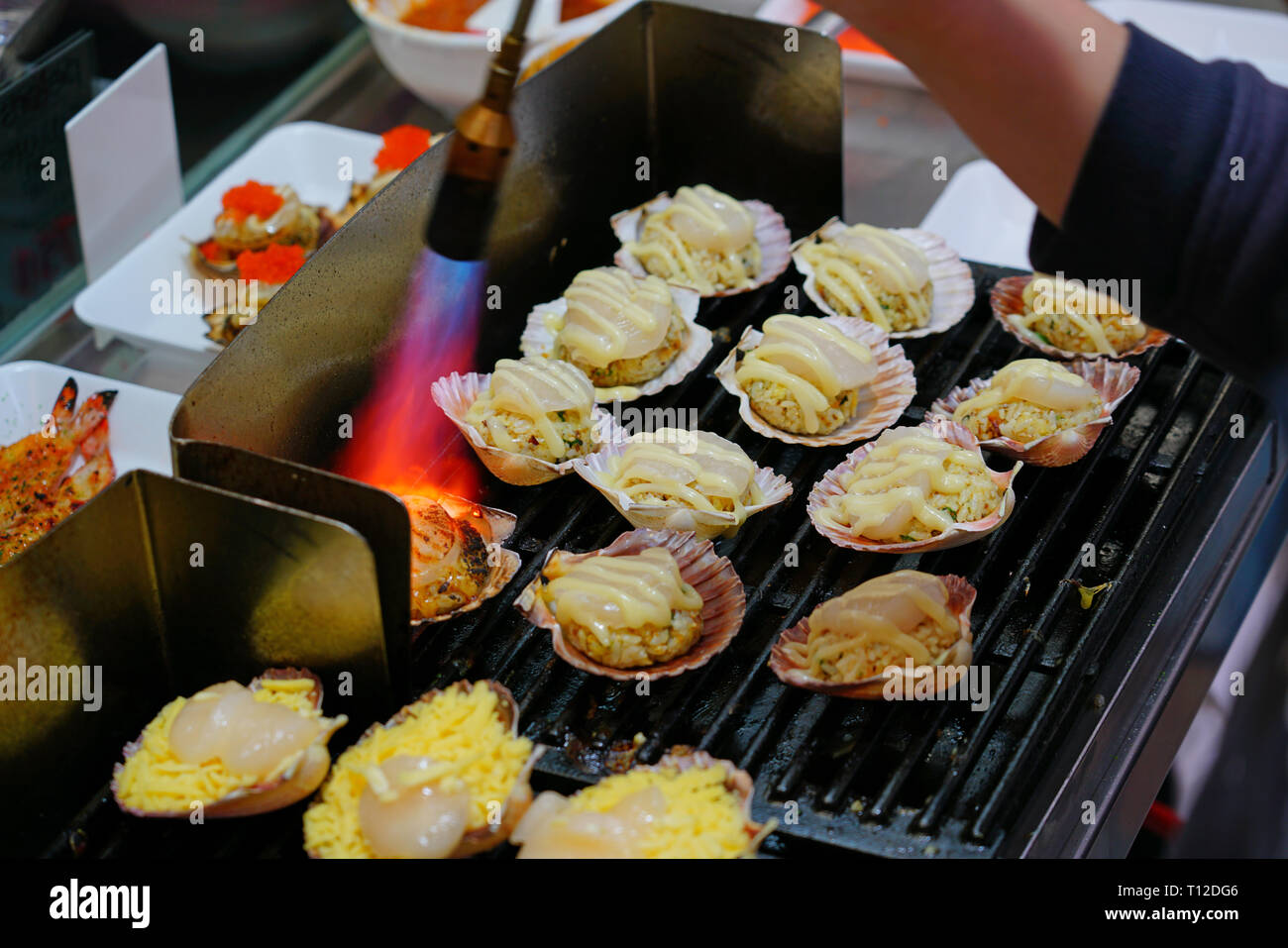 Broiled scallops with cheese on the shell at a fish market in Sydney ...