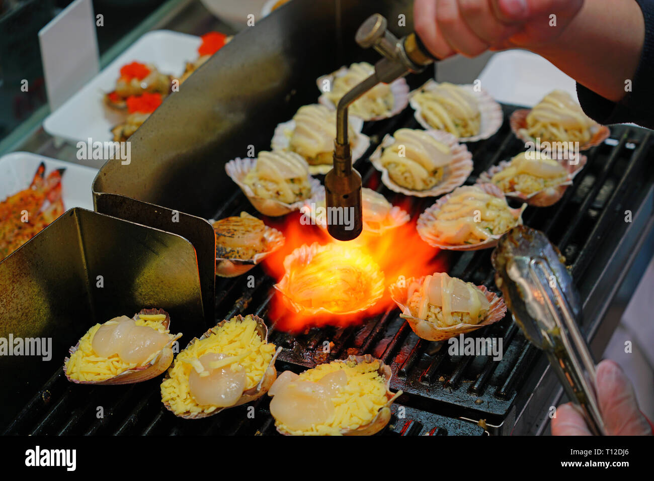 Broiled scallops with cheese on the shell at a fish market in Sydney ...