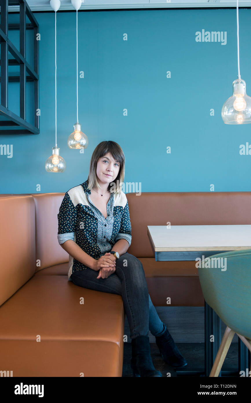 A young woman poses at a table in a cafe / restaurant Stock Photo - Alamy