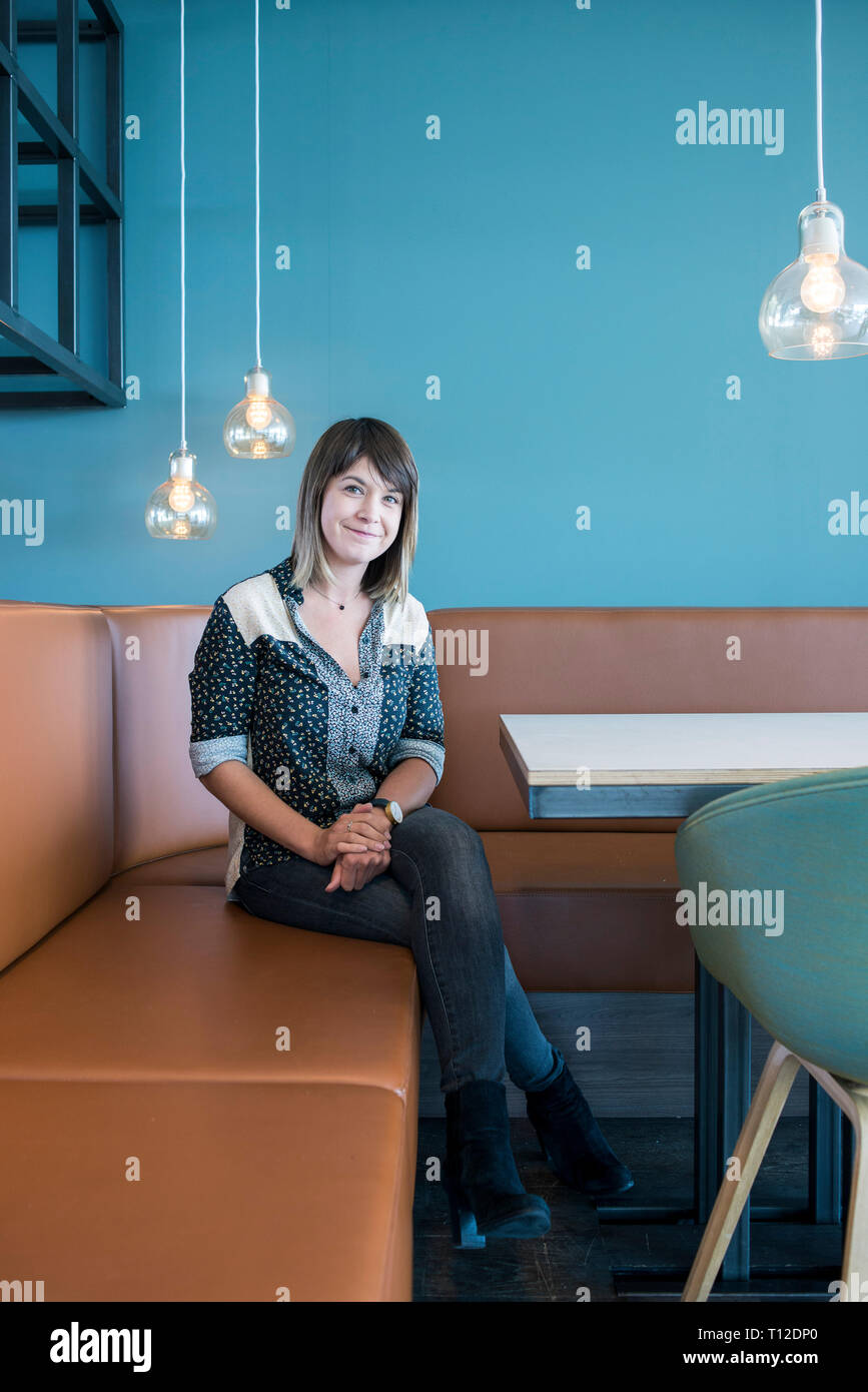 A young woman poses at a table in a cafe / restaurant Stock Photo - Alamy