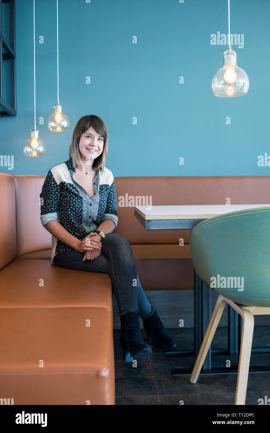 A young woman poses at a table in a cafe / restaurant Stock Photo - Alamy