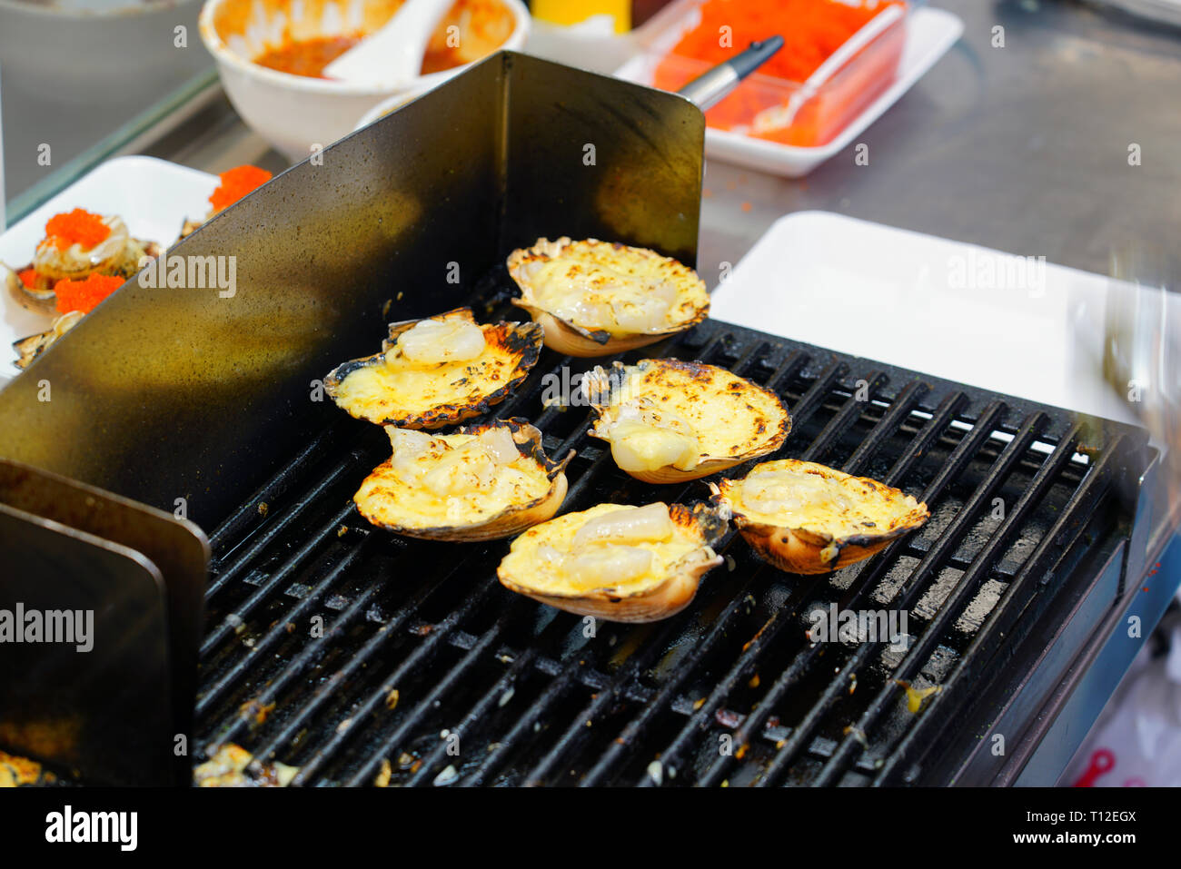 Broiled scallops with cheese on the shell at a fish market in Sydney ...