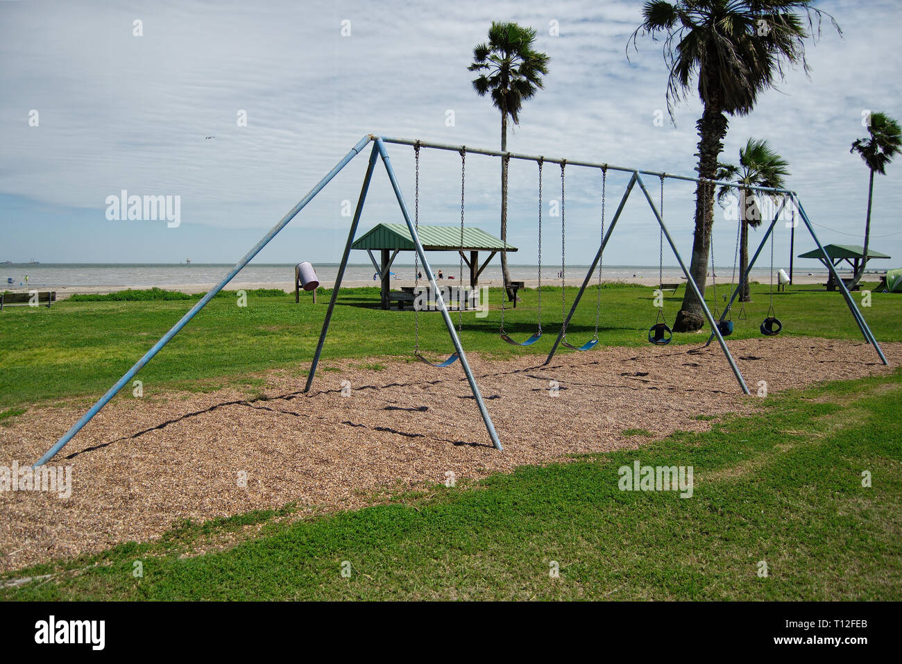 A playground swing set on the beach Stock Photo - Alamy